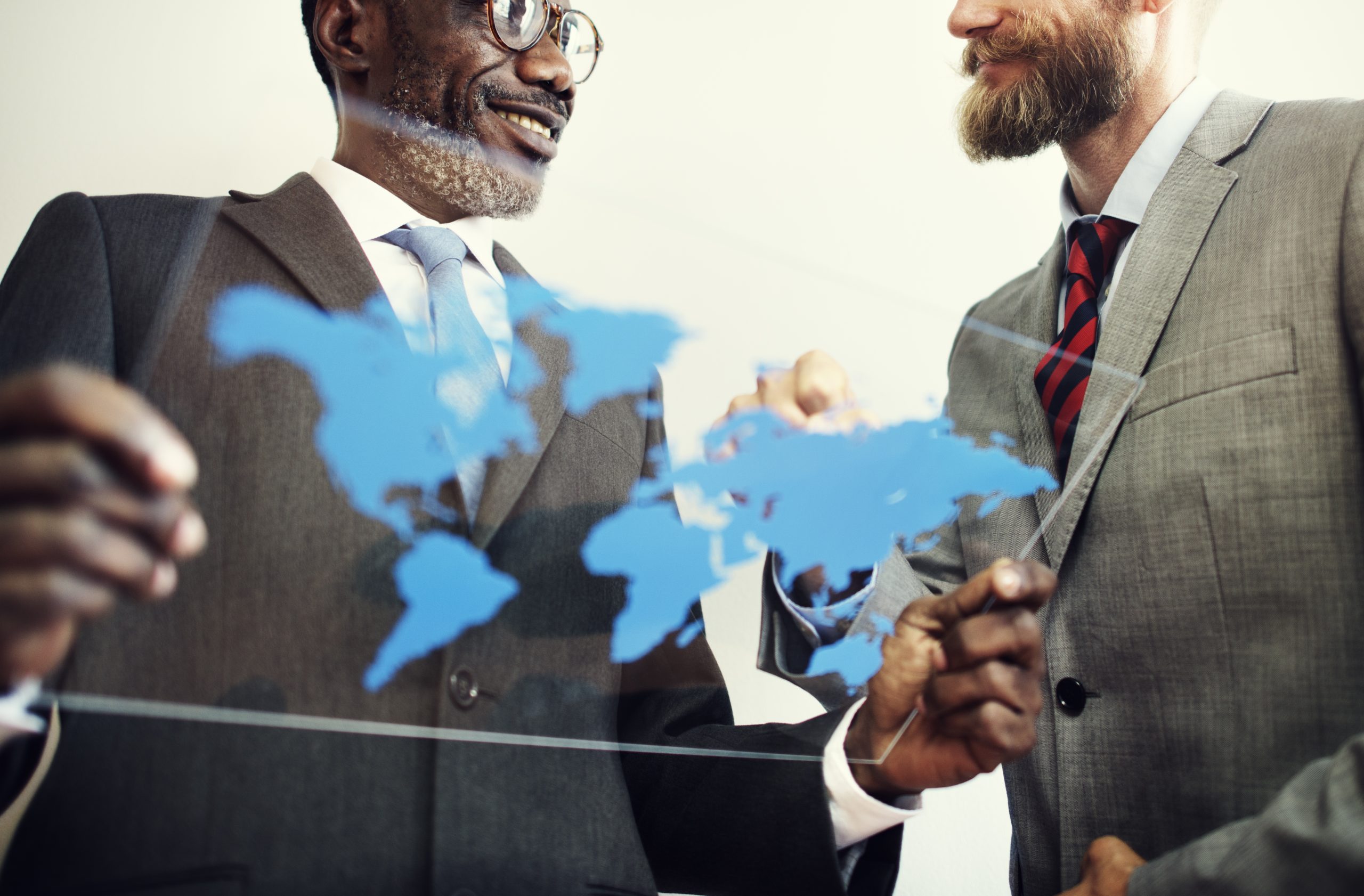 Businessmen World Map Glass Concept - Agostini Insurance Brokers Ltd